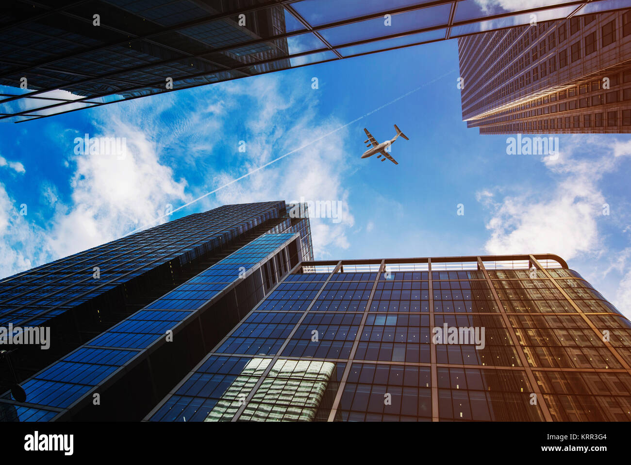 Airplane flying over business skyscrapers Stock Photo - Alamy