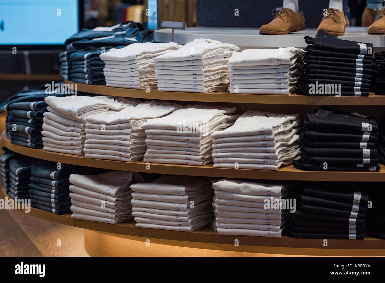 Stacks of clothes arranged on measure sizes in a store Stock Photo - Alamy