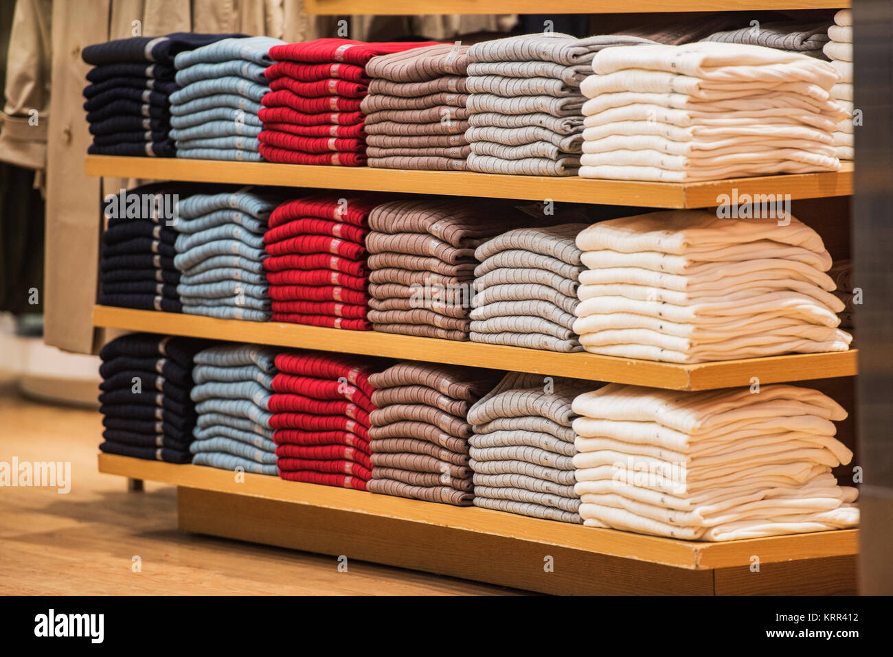 Stacks of clothes arranged on measure sizes in a store Stock Photo - Alamy