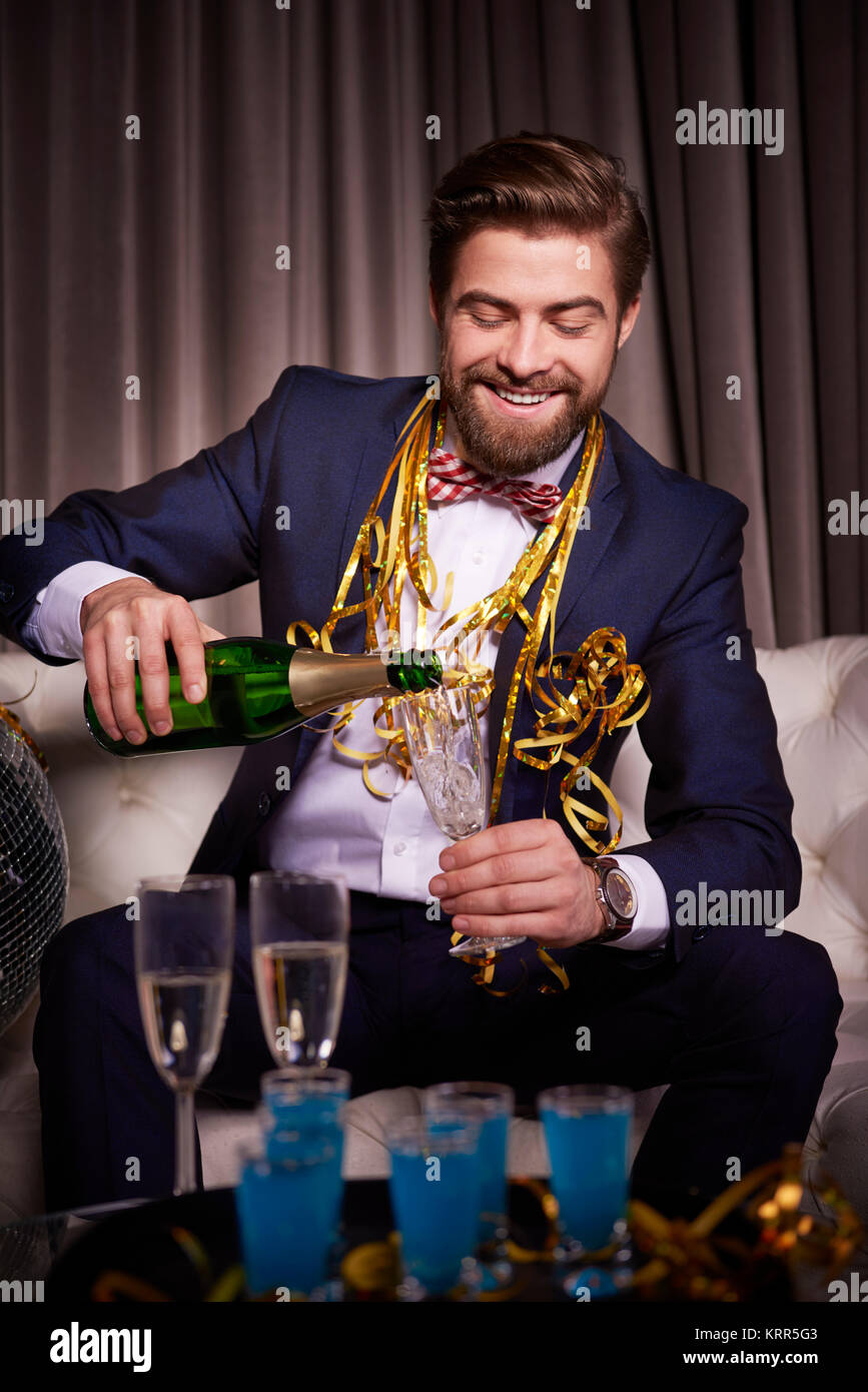 Cheerful man pouring a champagne flute of champagne Stock Photo - Alamy Cheerful man pouring a champagne flute of champagne Stock Photo - Alamy
