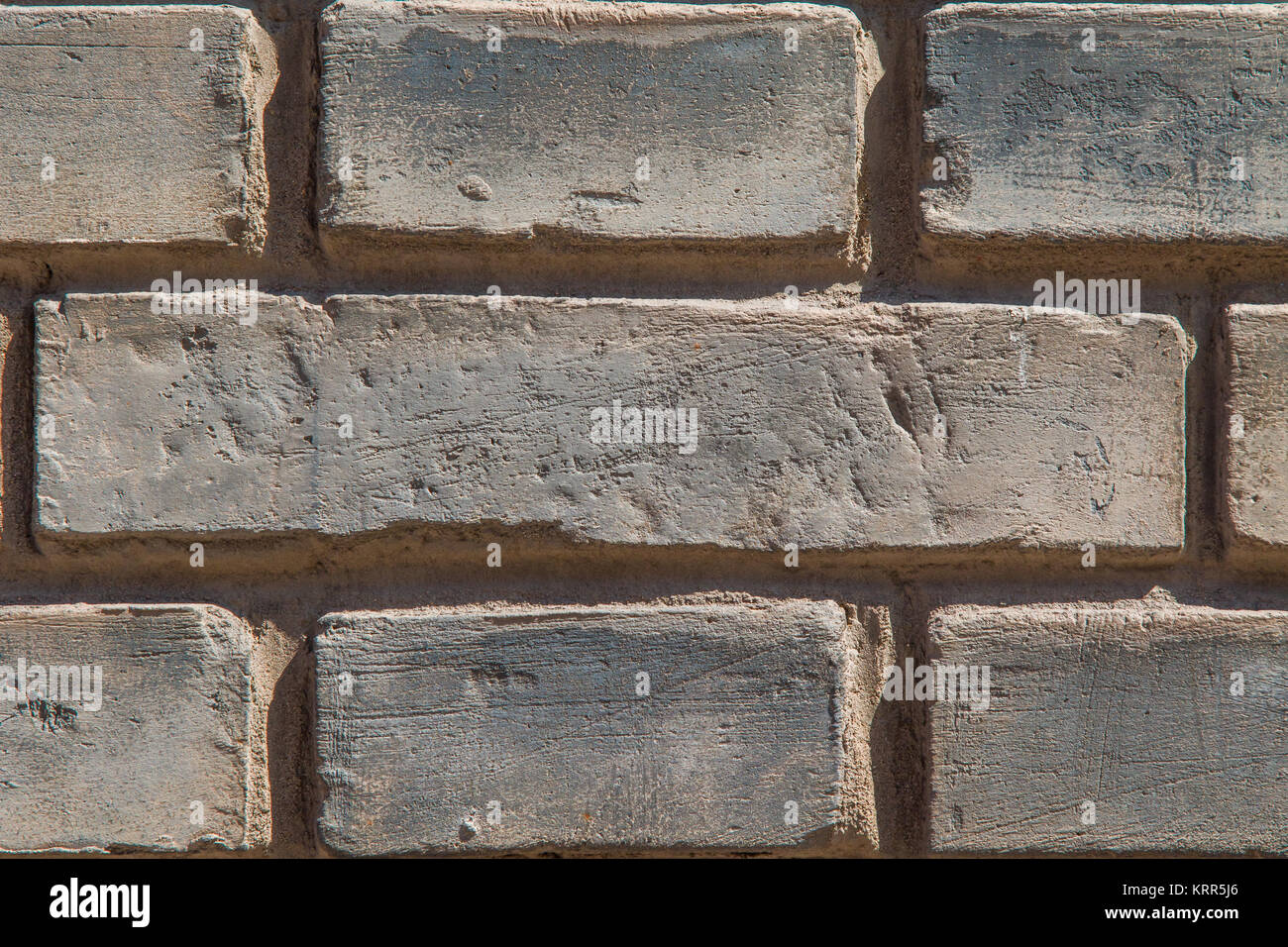Close up of an old gray brick wall revealing it's scratched surface ...