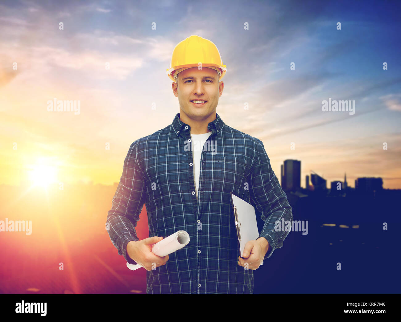 builder in hard hat with blueprint and clipboard Stock Photo - Alamy