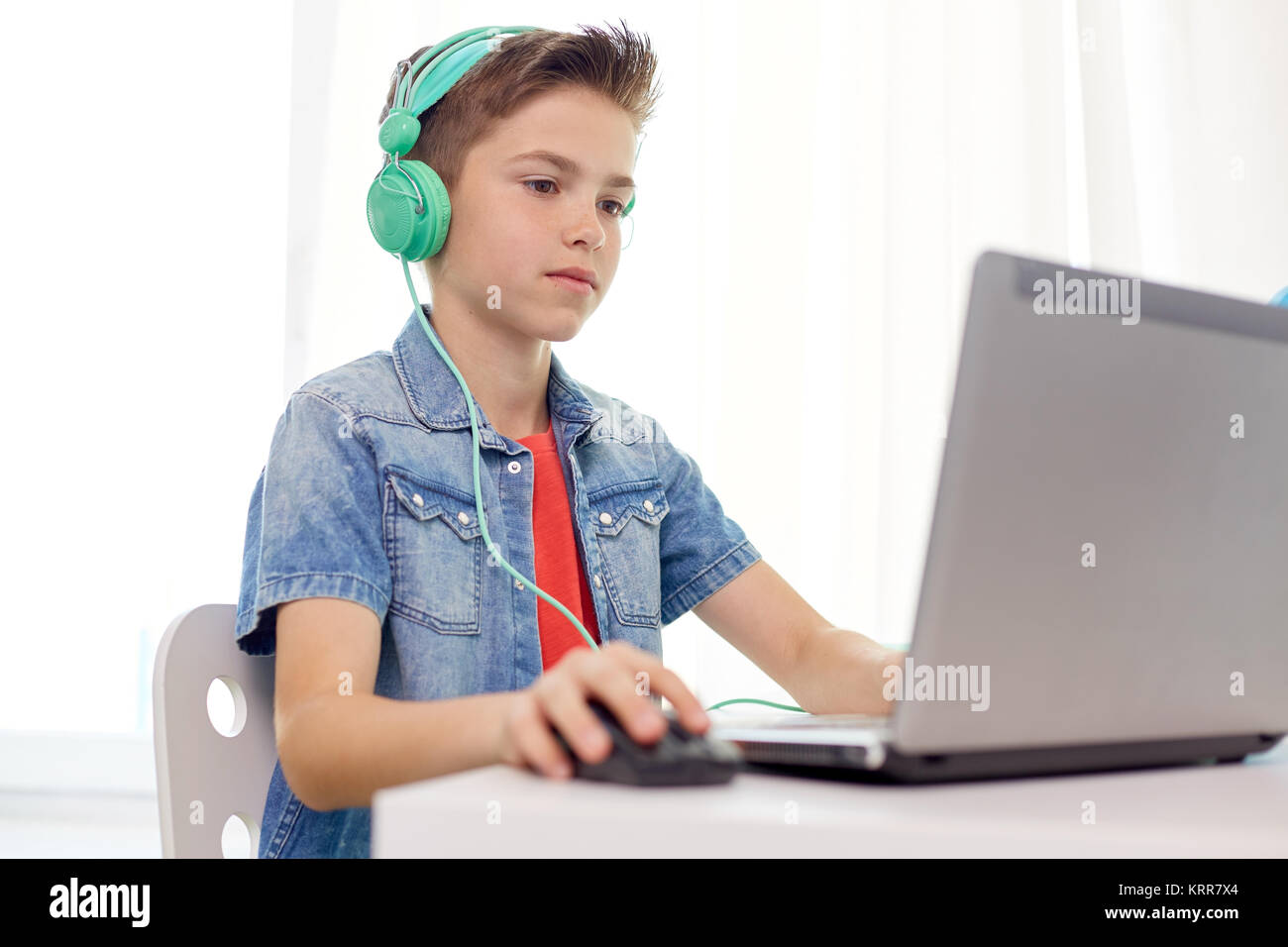 boy in headphones playing video game on laptop Stock Photo - Alamy