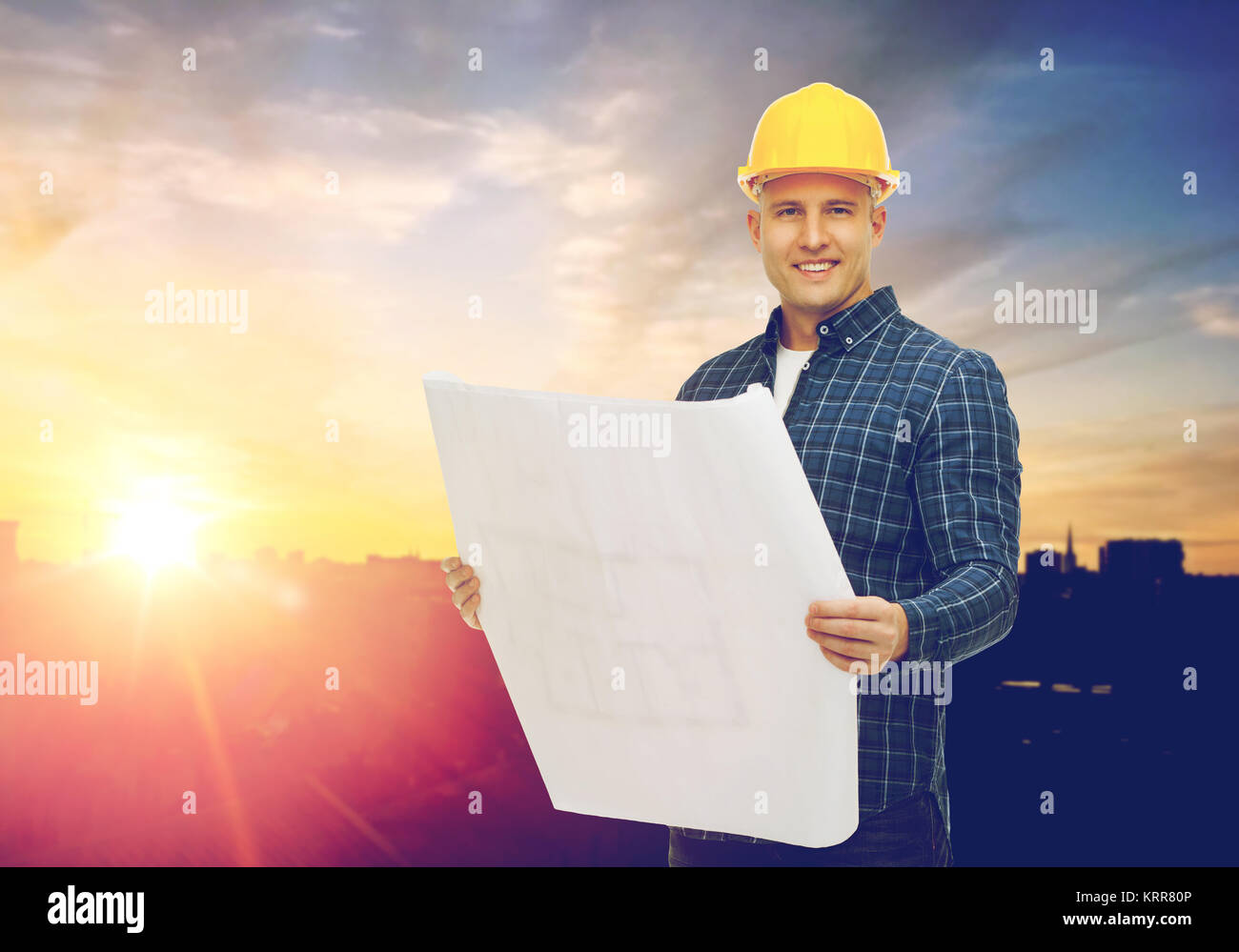 male builder in yellow hard hat with blueprint Stock Photo - Alamy
