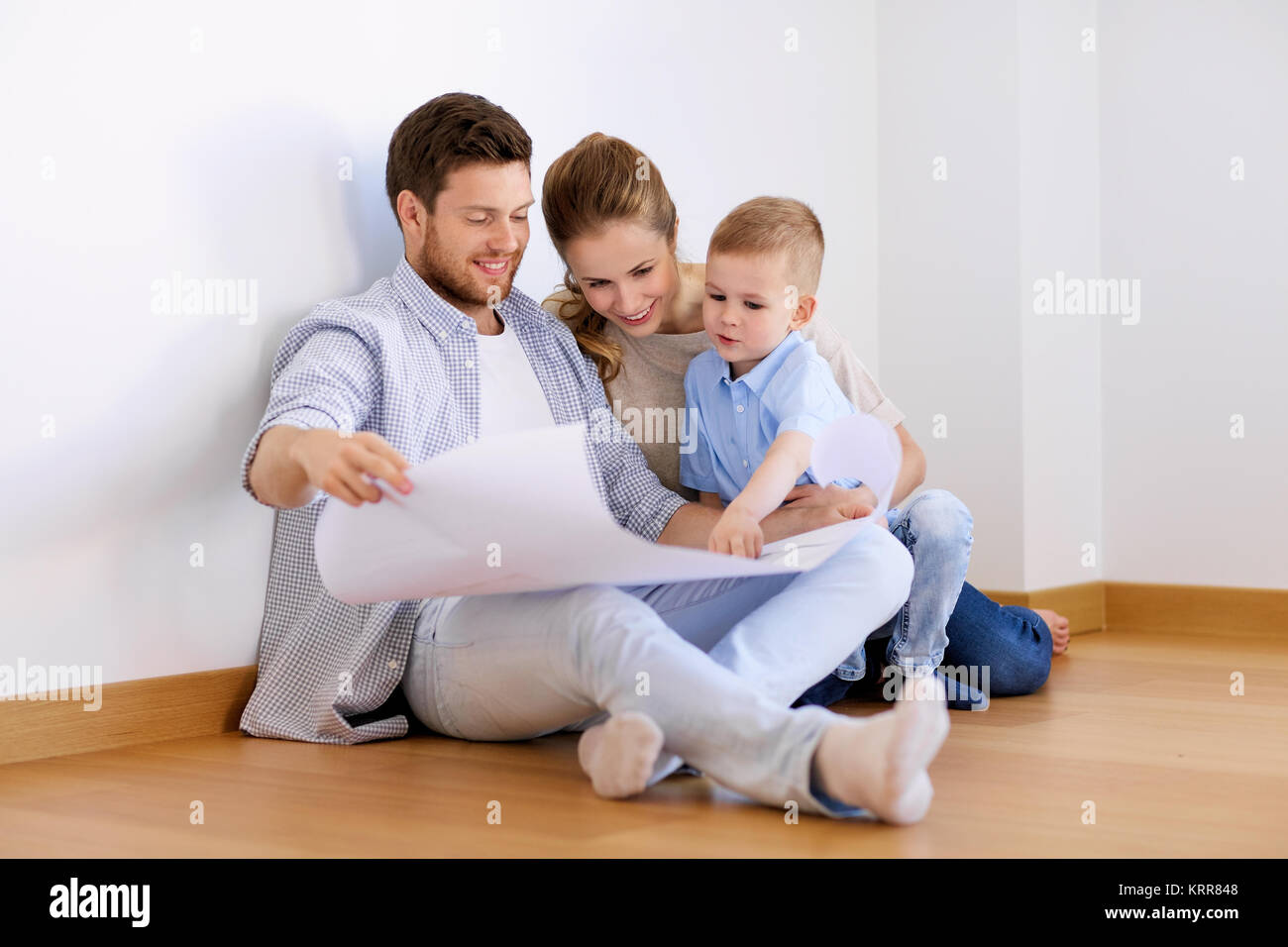 happy family with blueprint moving to new home Stock Photo - Alamy