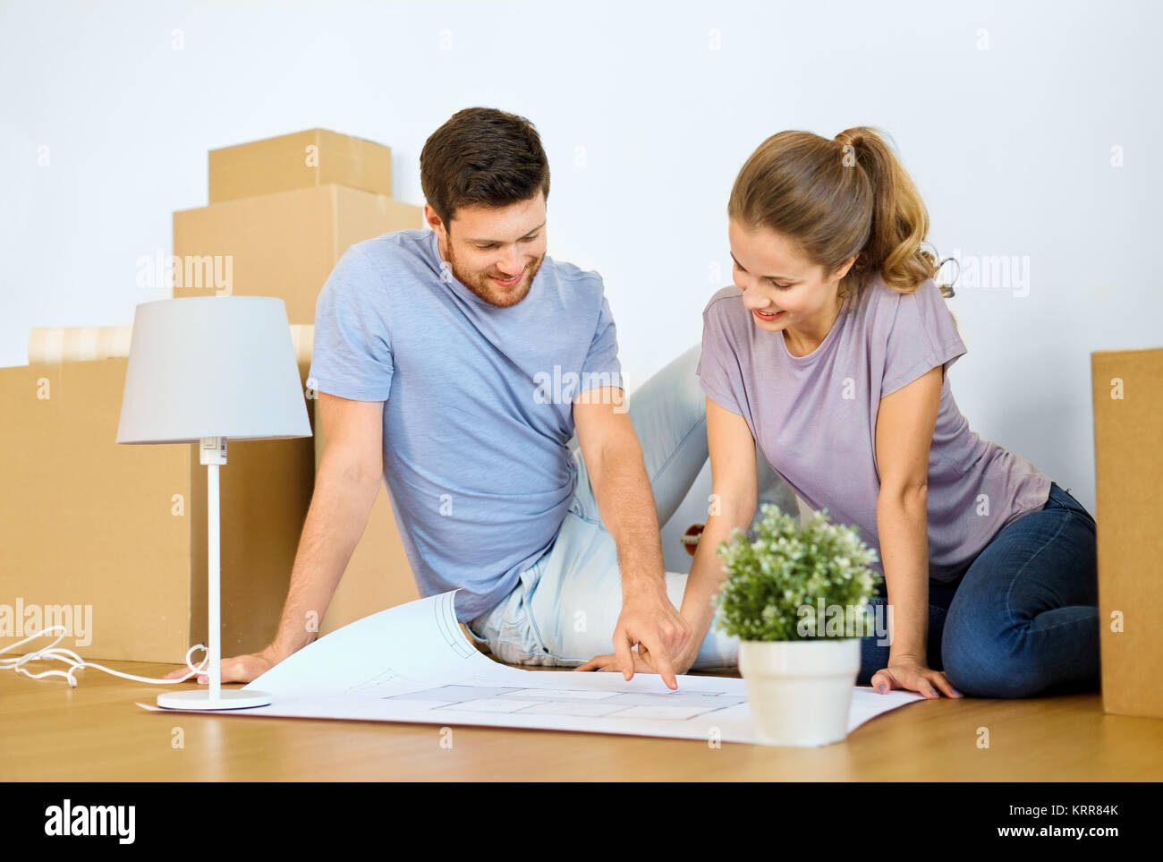 couple with boxes and blueprint moving to new home Stock Photo - Alamy