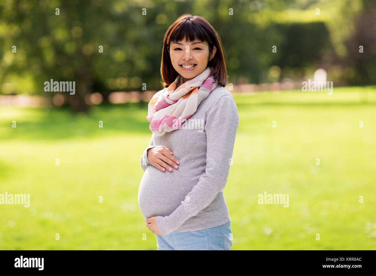 happy pregnant asian woman at park Stock Photo - Alamy