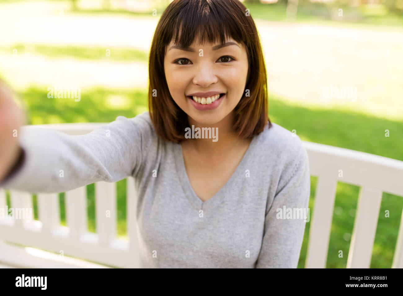 happy smiling asian woman taking selfie at park Stock Photo - Alamy