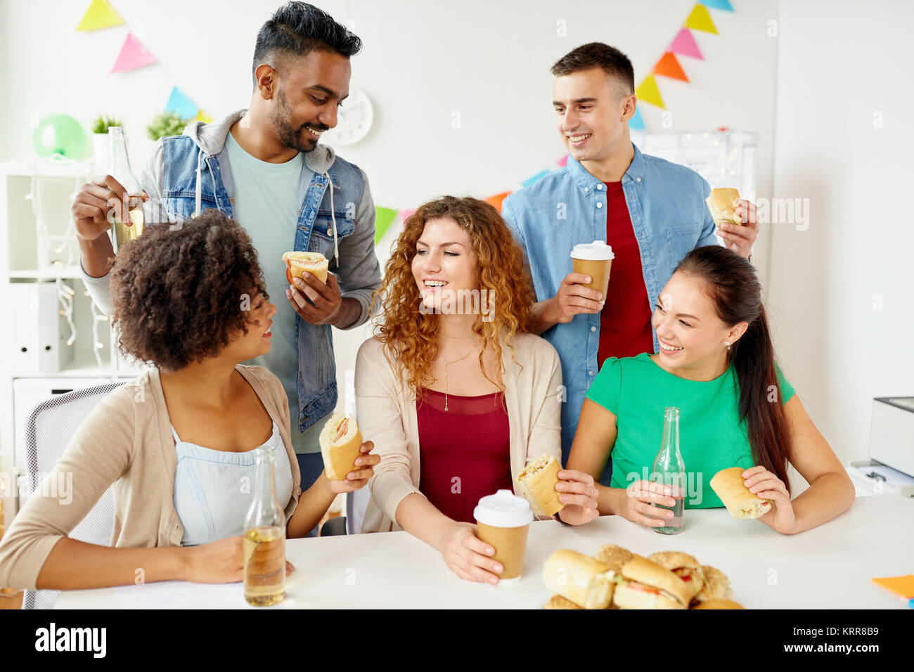 happy friends or team eating at office party Stock Photo - Alamy