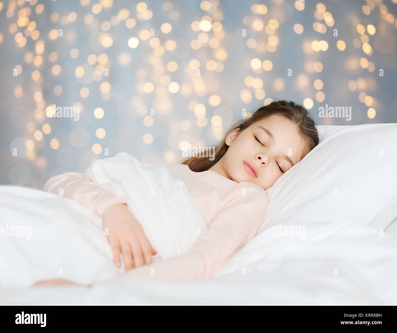 girl sleeping in bed over holidays lights Stock Photo - Alamy