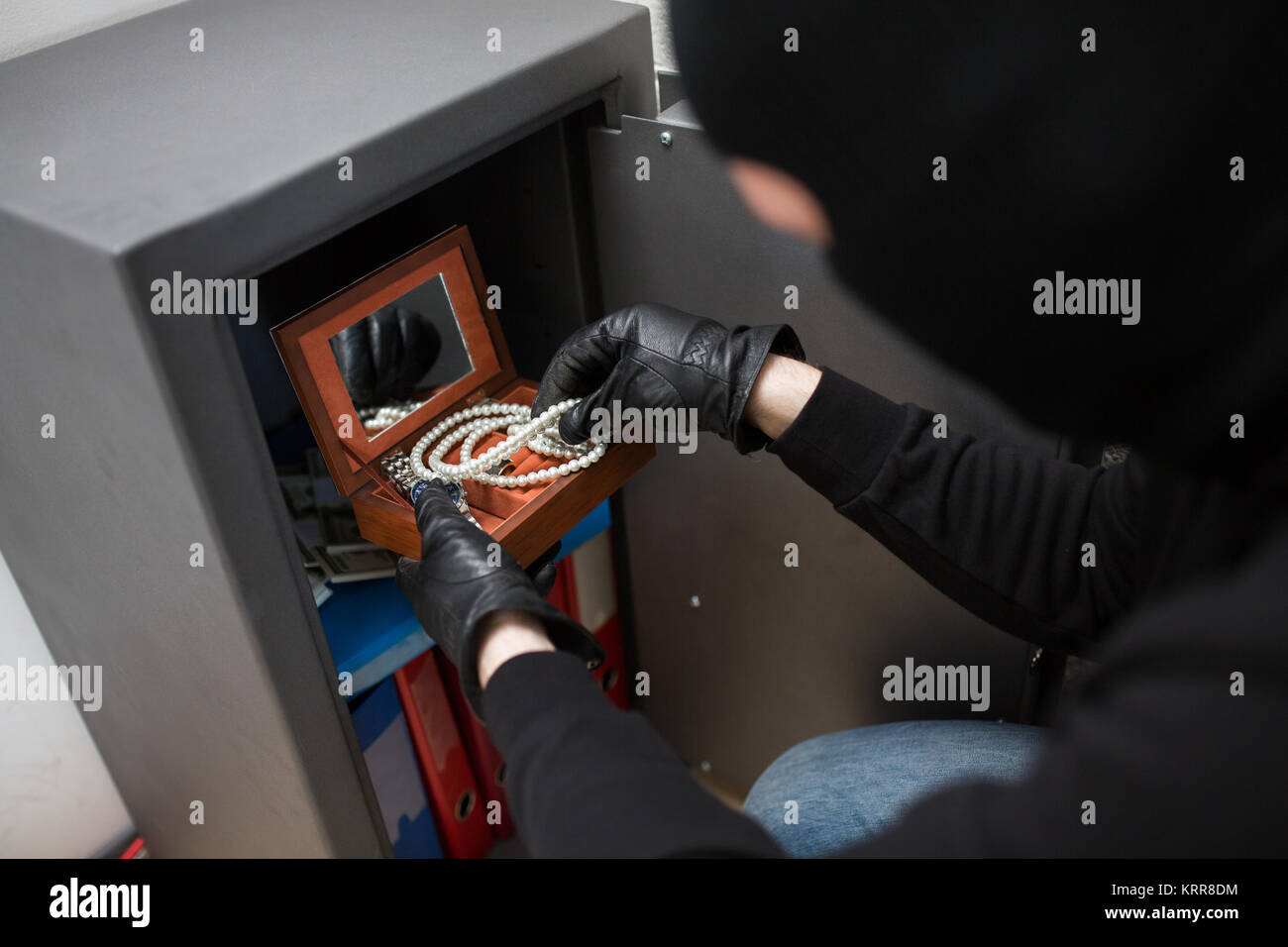 thief stealing valuables from safe at crime scene Stock Photo - Alamy