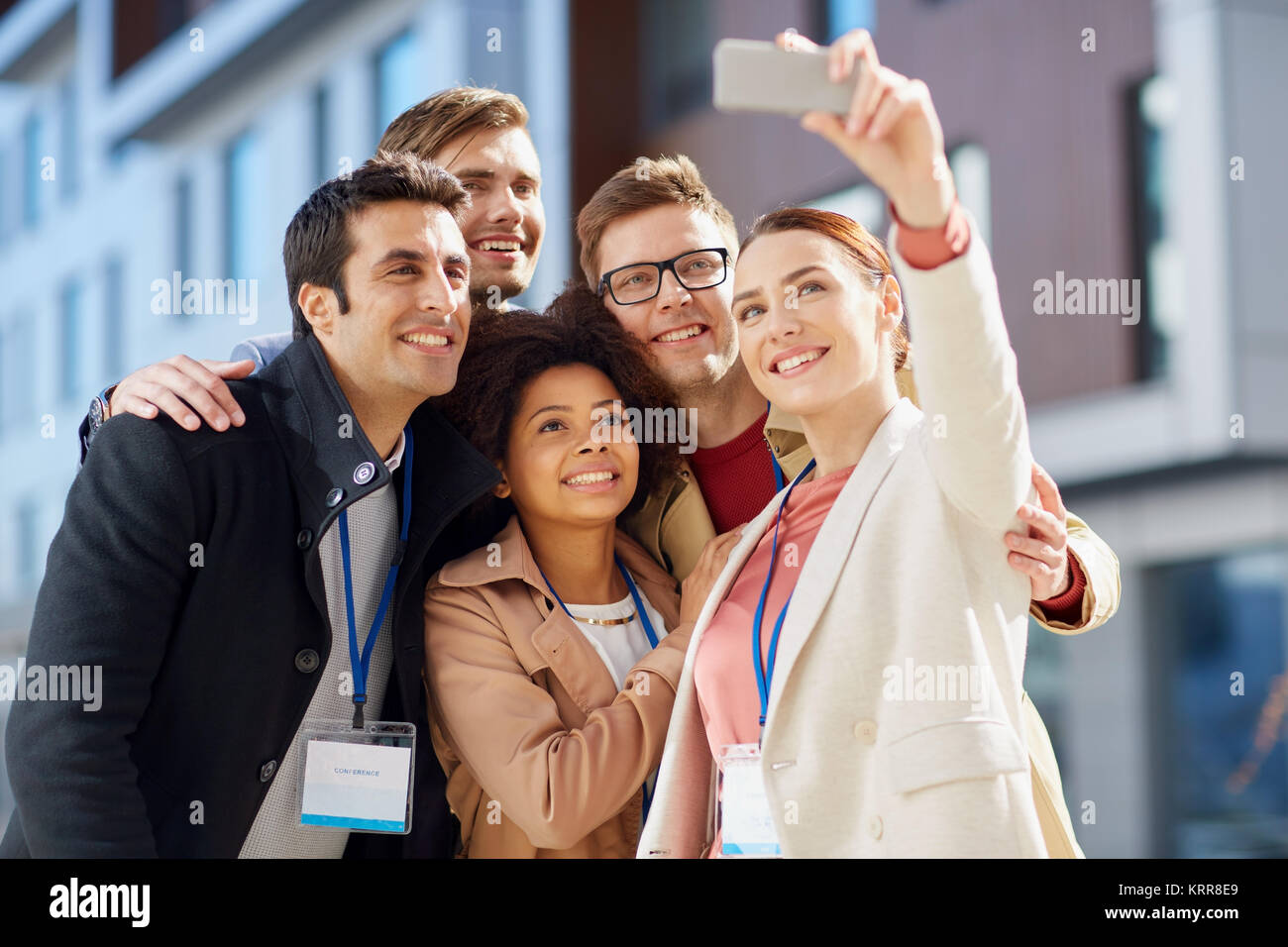 business team with conference badges taking selfie Stock Photo - Alamy