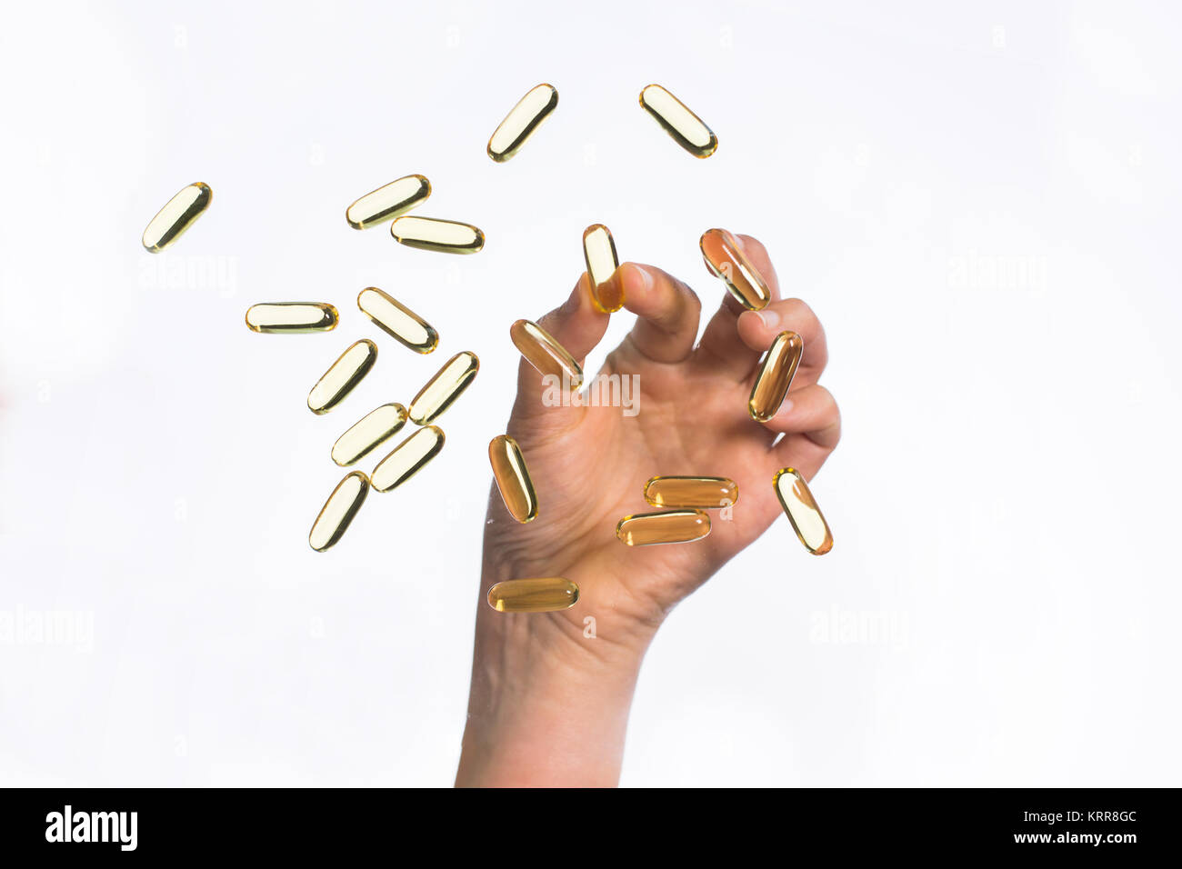 hand picking cod liver oil capsules up Stock Photo - Alamy