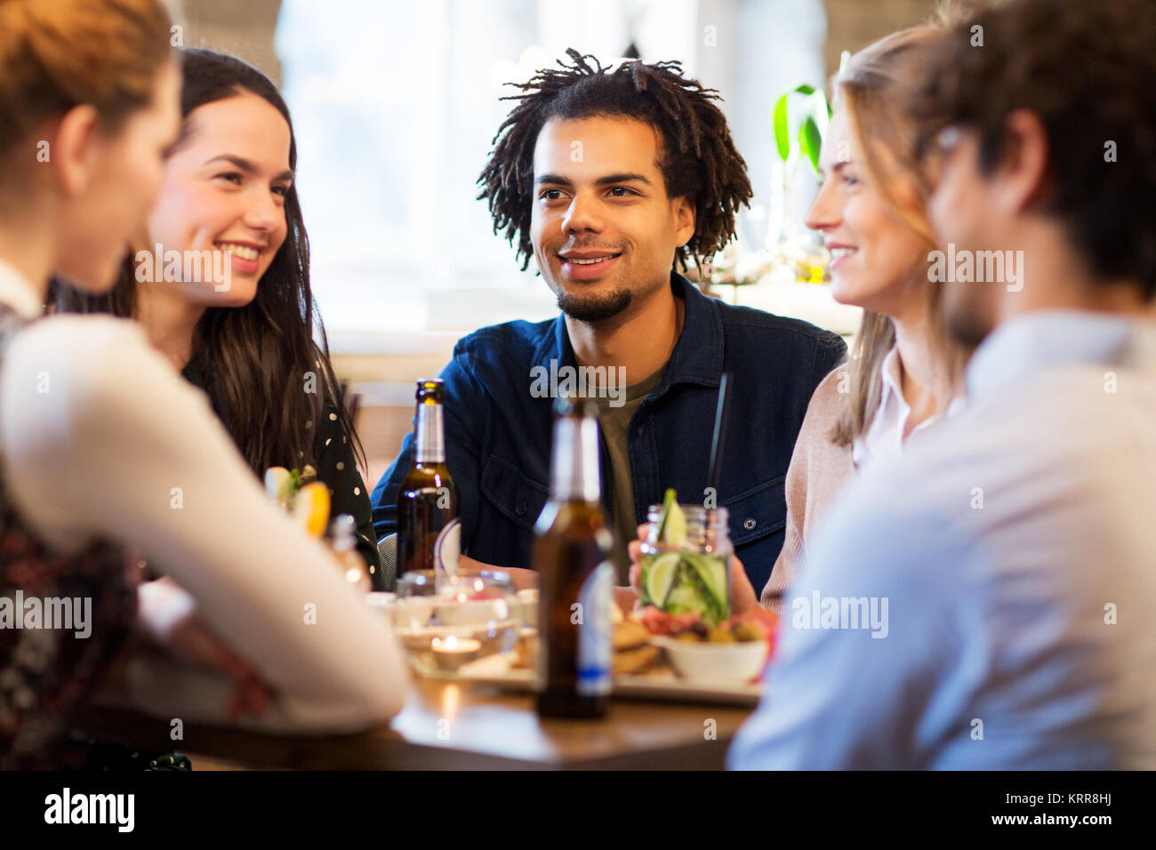 happy friends eating at bar or restaurant Stock Photo - Alamy