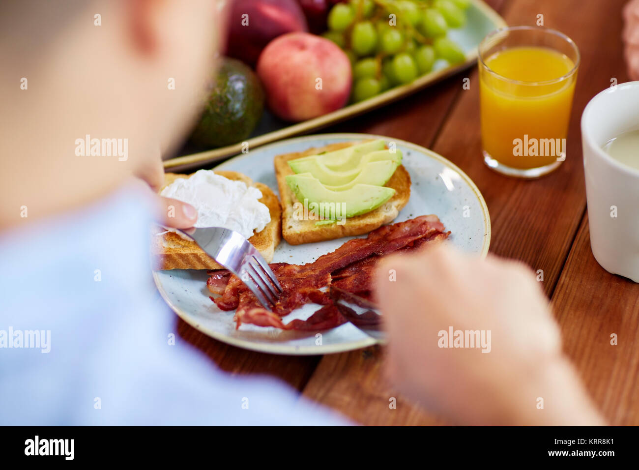 man eating toast with mozzarella, egg and bacon Stock Photo - Alamy