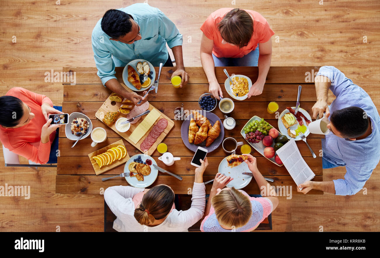 people with smartphones eating food at table Stock Photo - Alamy