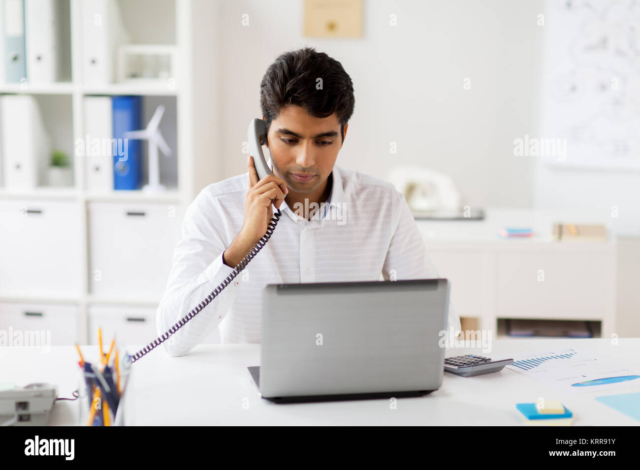 businessman calling on desk phone at office Stock Photo - Alamy