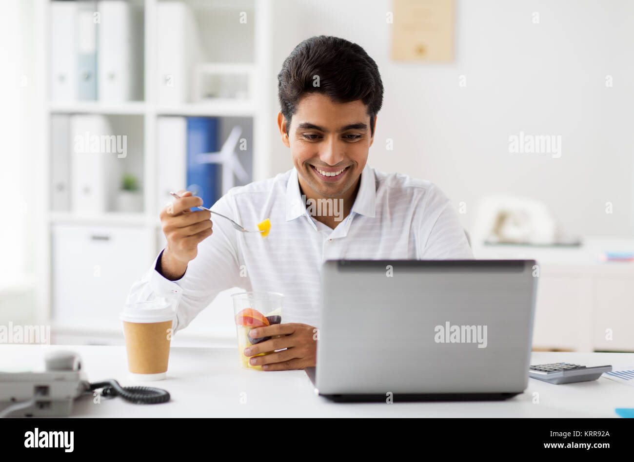 businessman with laptop eating fruits at office Stock Photo - Alamy