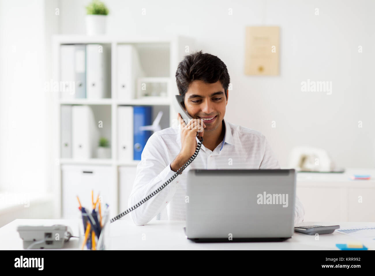 happy businessman calling on desk phone at office Stock Photo - Alamy