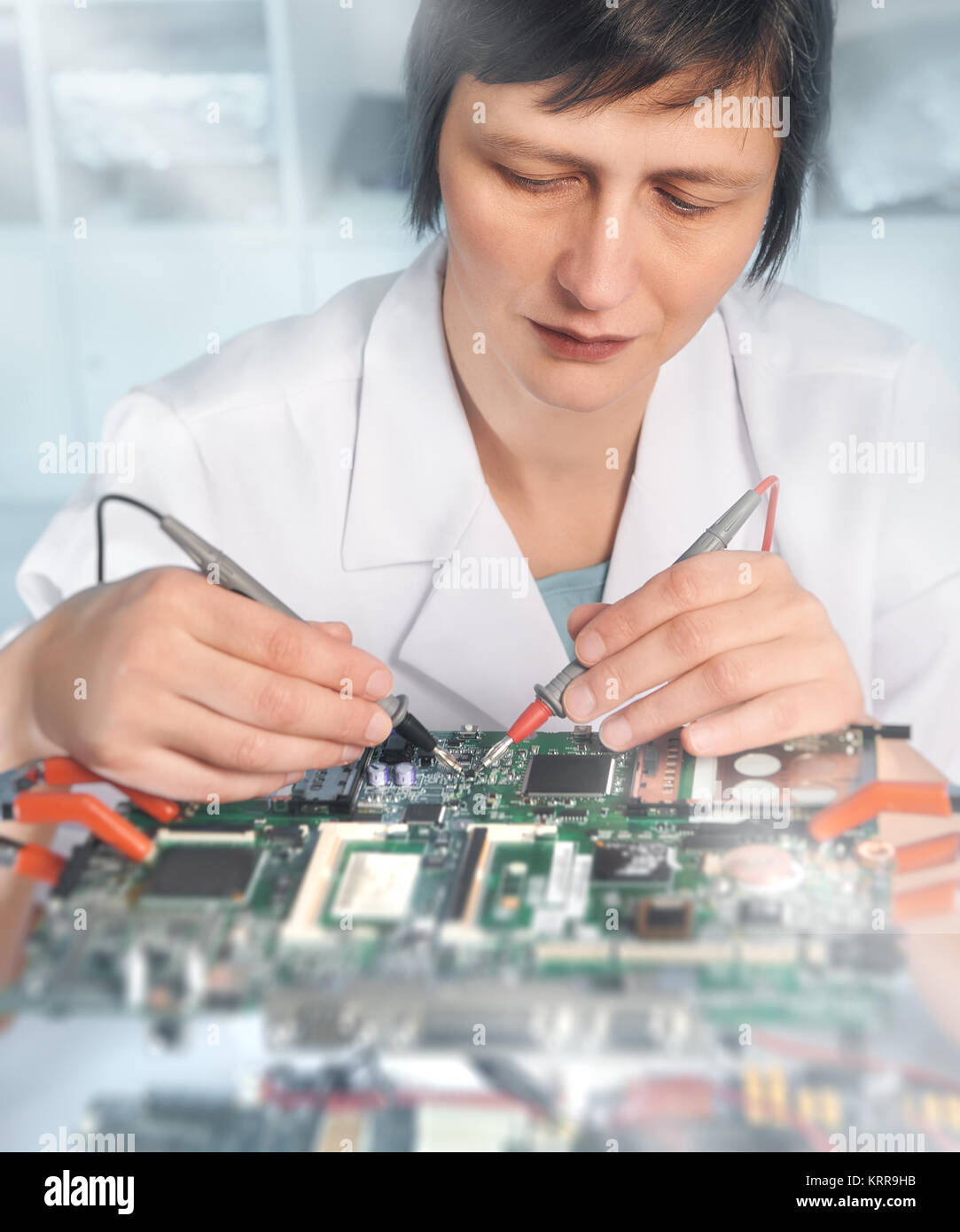 Mature caucasian female engineer or tech repairs electronic device in ...