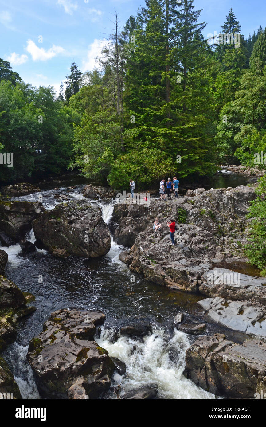 People climbing on the rocks, at Betws-y-Coed waterfall, River Conwy ...