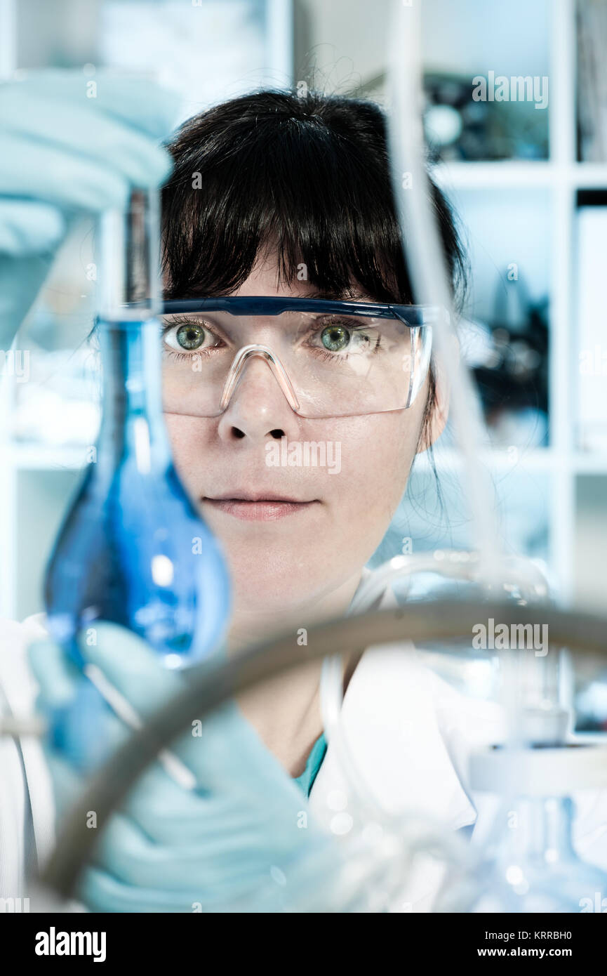 Female tech in protective wear works in chemical lab Stock Photo - Alamy