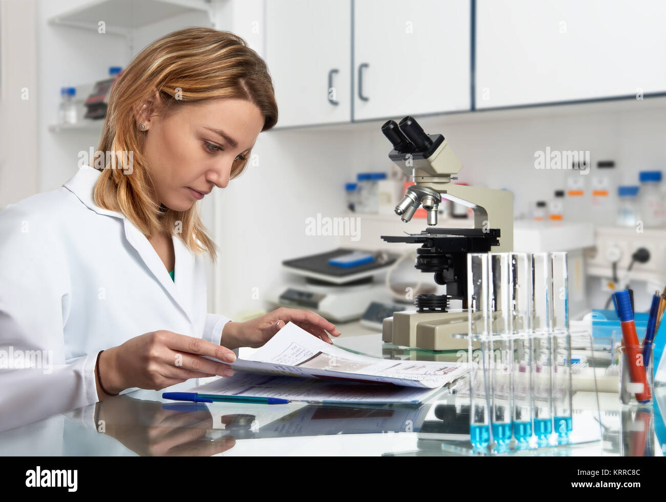 Young European female scientist checks her laboratory journal in the ...