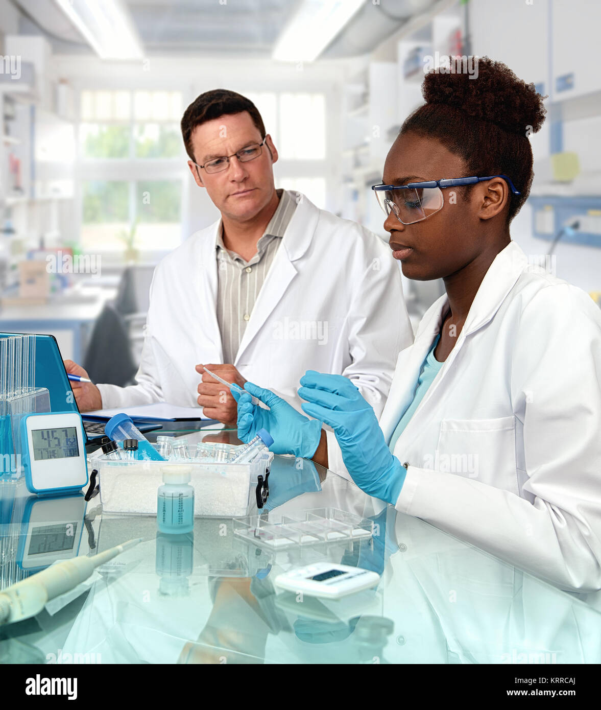 Scientists, senior Caucasian male and young African female, work in the ...