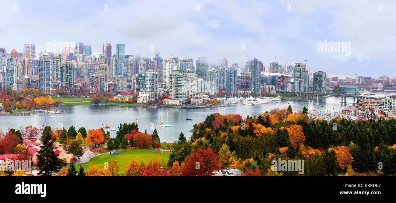 colorful autumn landscape of a modern city with yachts and skyscrapers ...