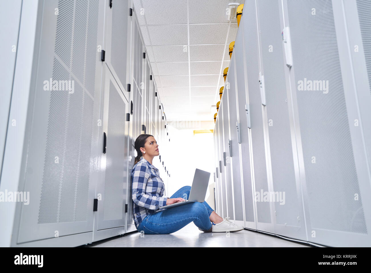 female technician working on server maintenance in white server room ...