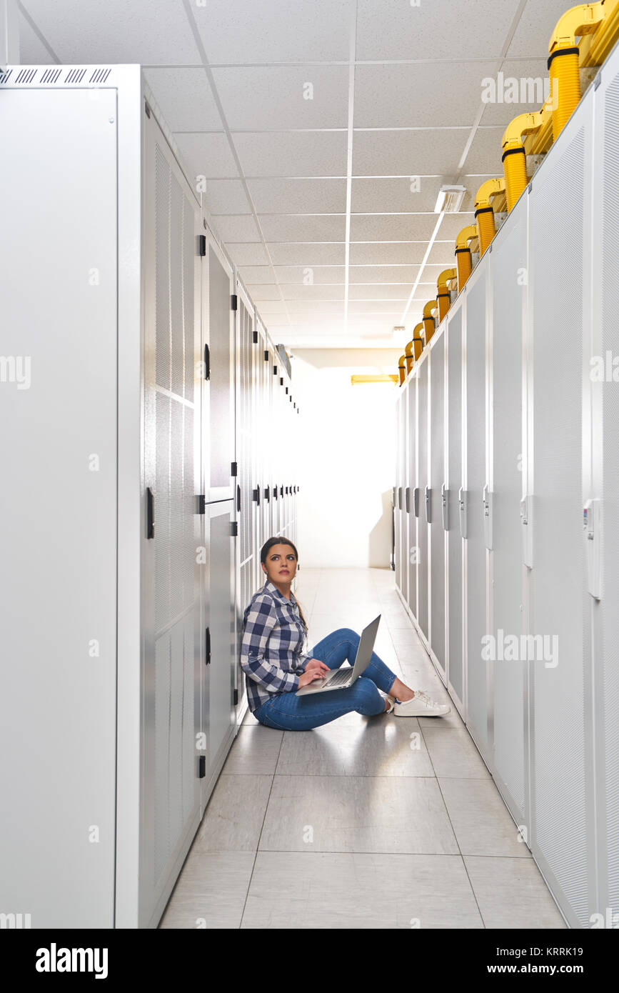 female technician working on server maintenance in white server room ...
