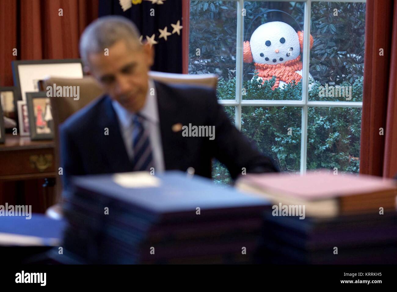 A snowman peers through the window as U.S. President Barack Obama works ...
