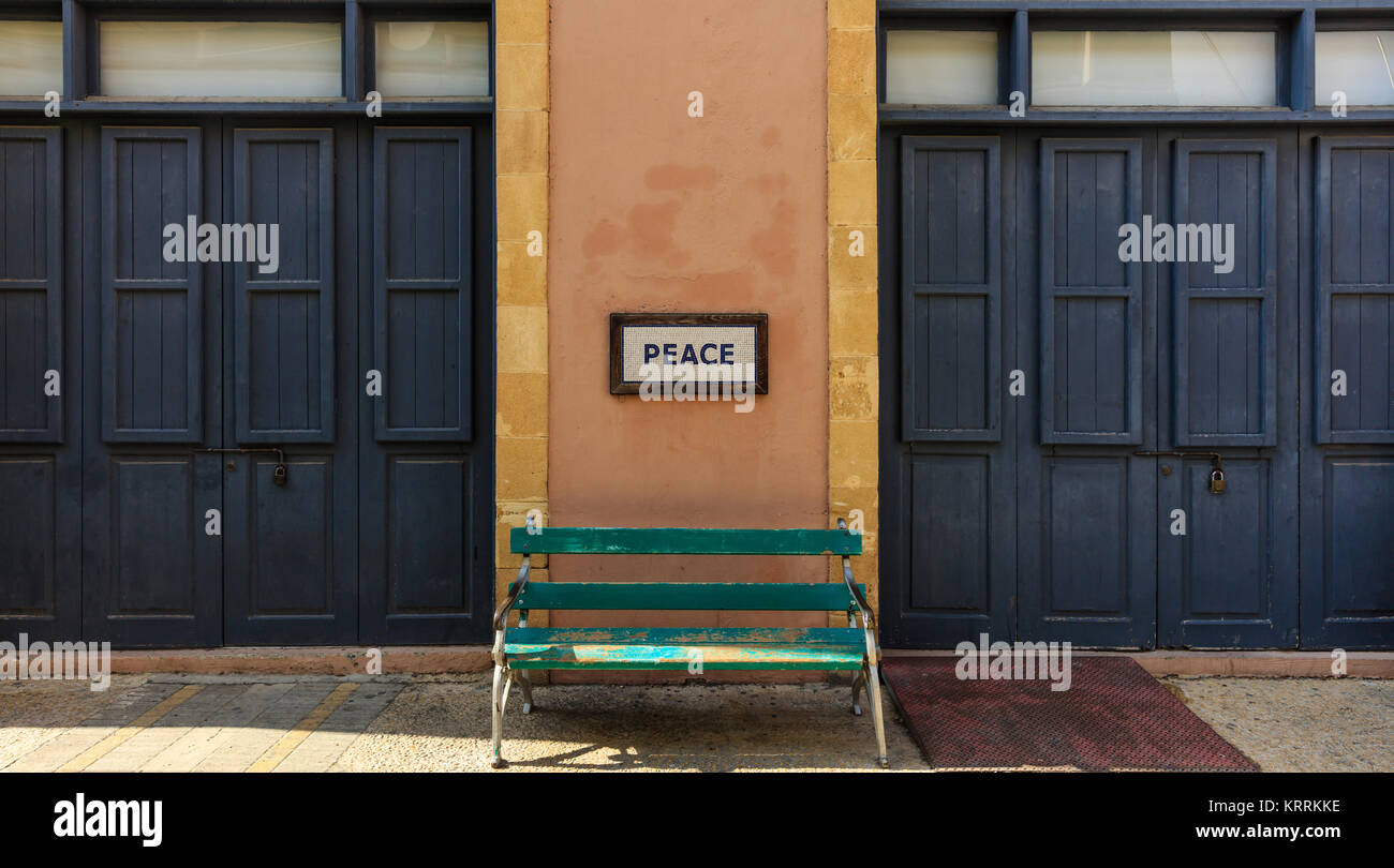 Word peace framed above an old wooden bench on a column between two ...