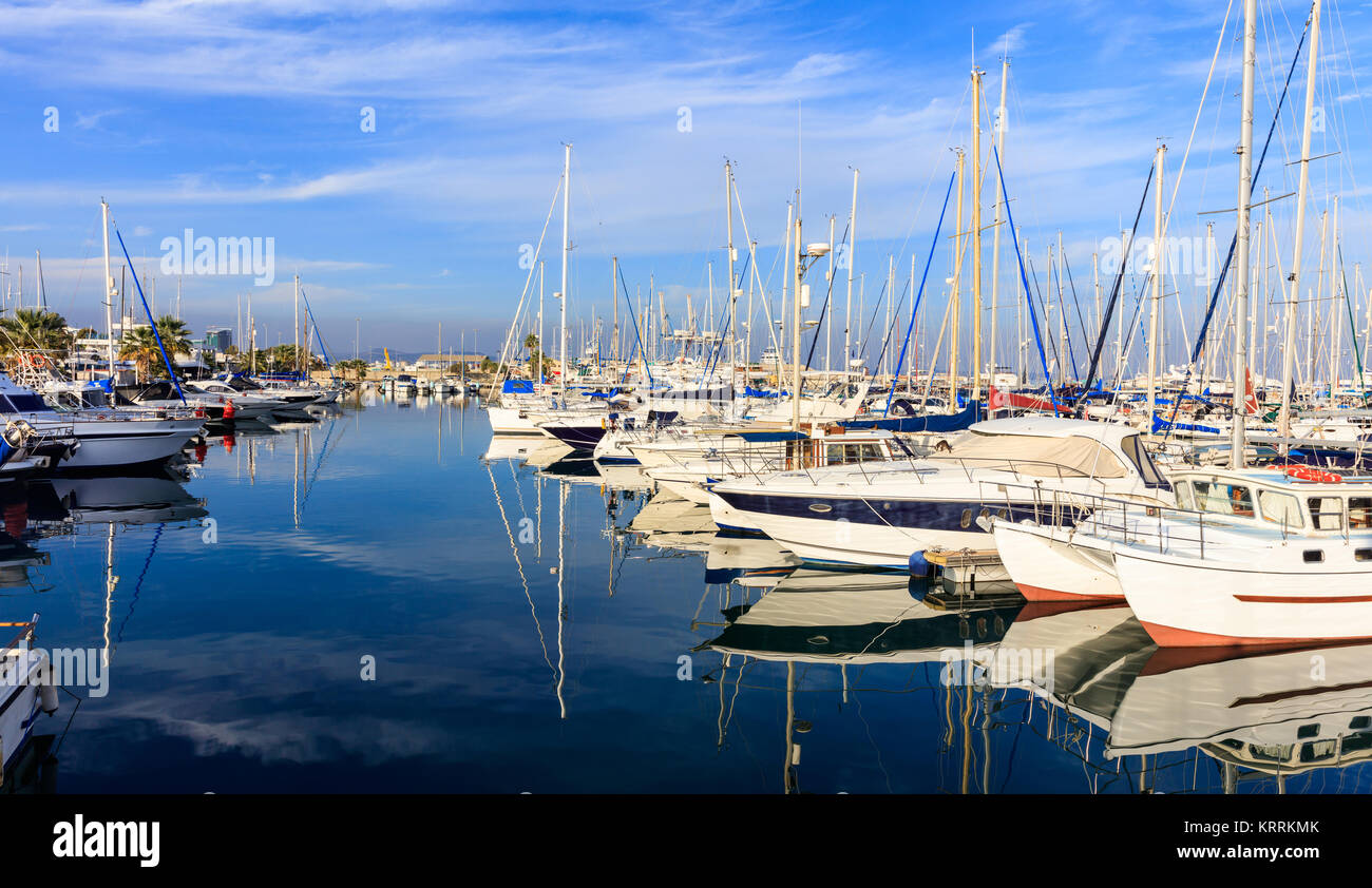 Reflection of several boats moored in a marina at Larnaca, Cyprus. Blue ...