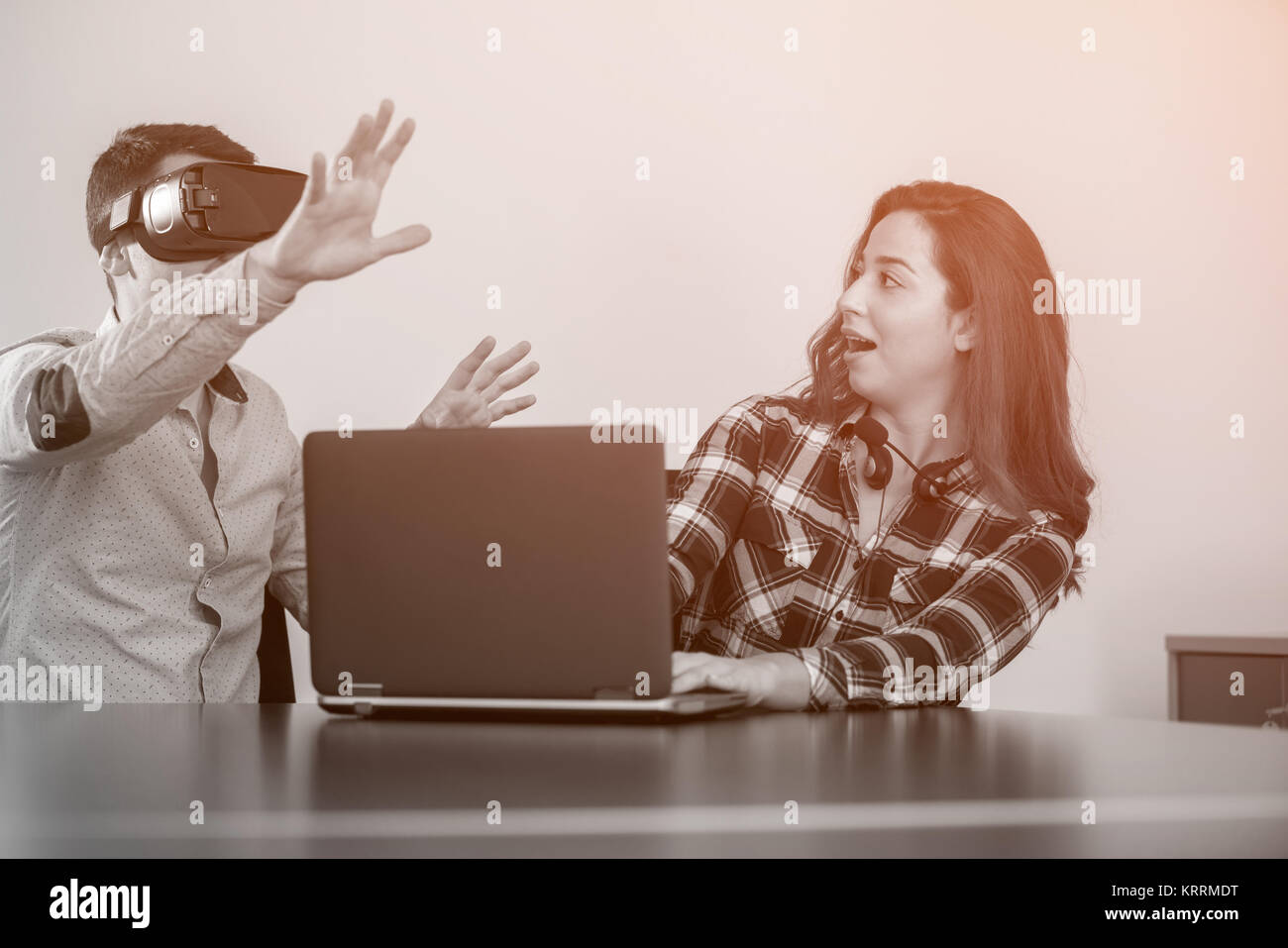 Couple having fun trying VR headset at startup meeting, concept ...