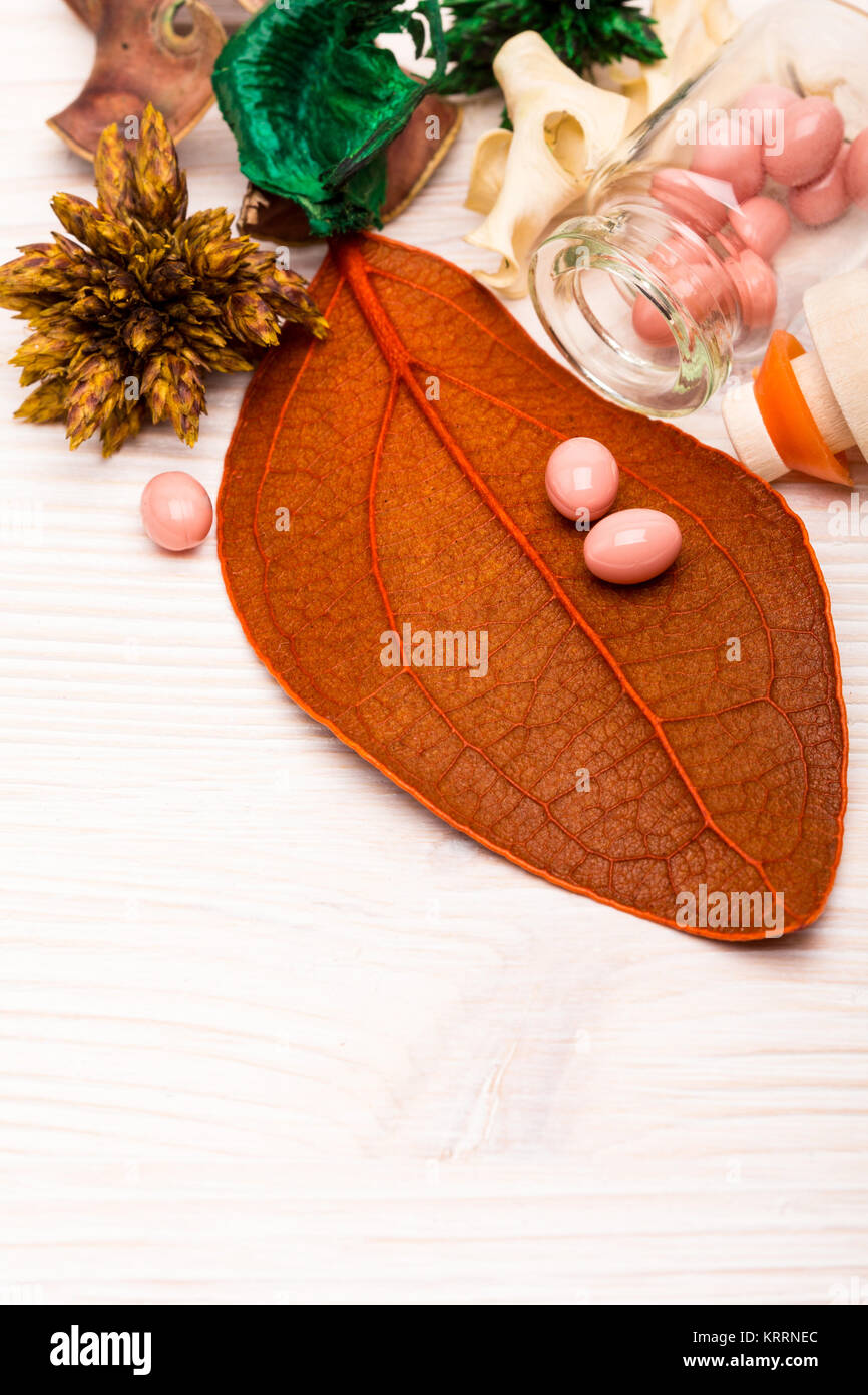 Pink ball shape pills on orange leaf Stock Photo - Alamy