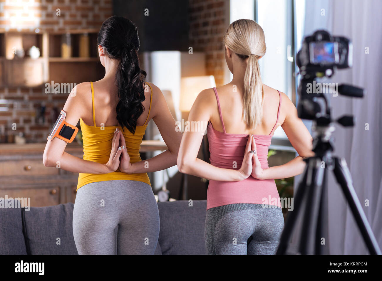 Nice well built women holding hands behind their backs Stock Photo - Alamy