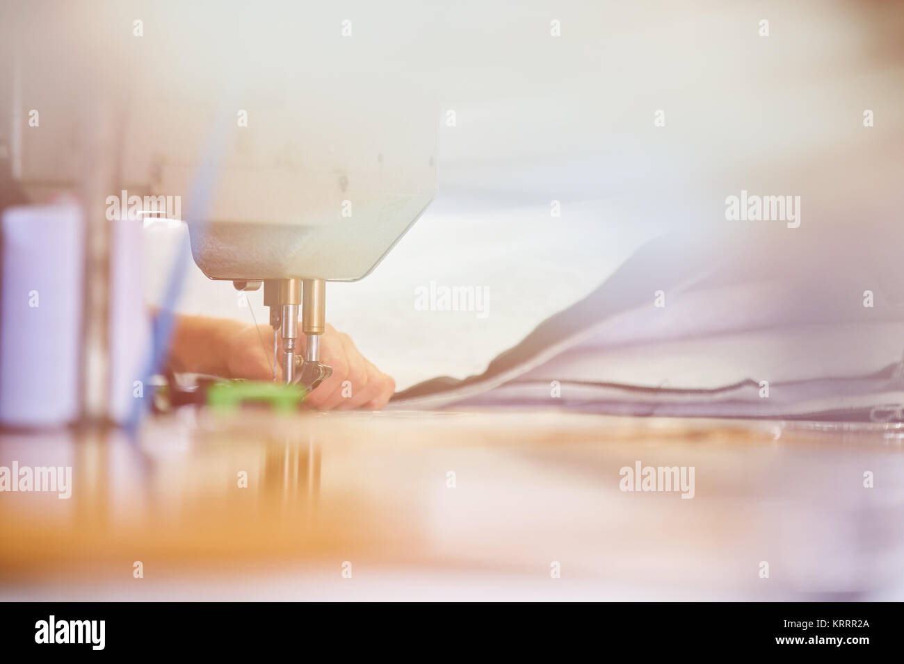 Seamstress or worker in a factory sewing with a industrial sewing ...