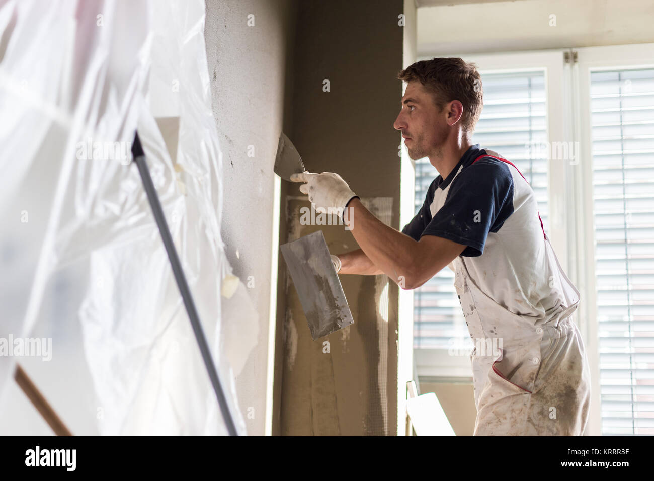 Plasterer renovating indoor walls and ceilings Stock Photo - Alamy