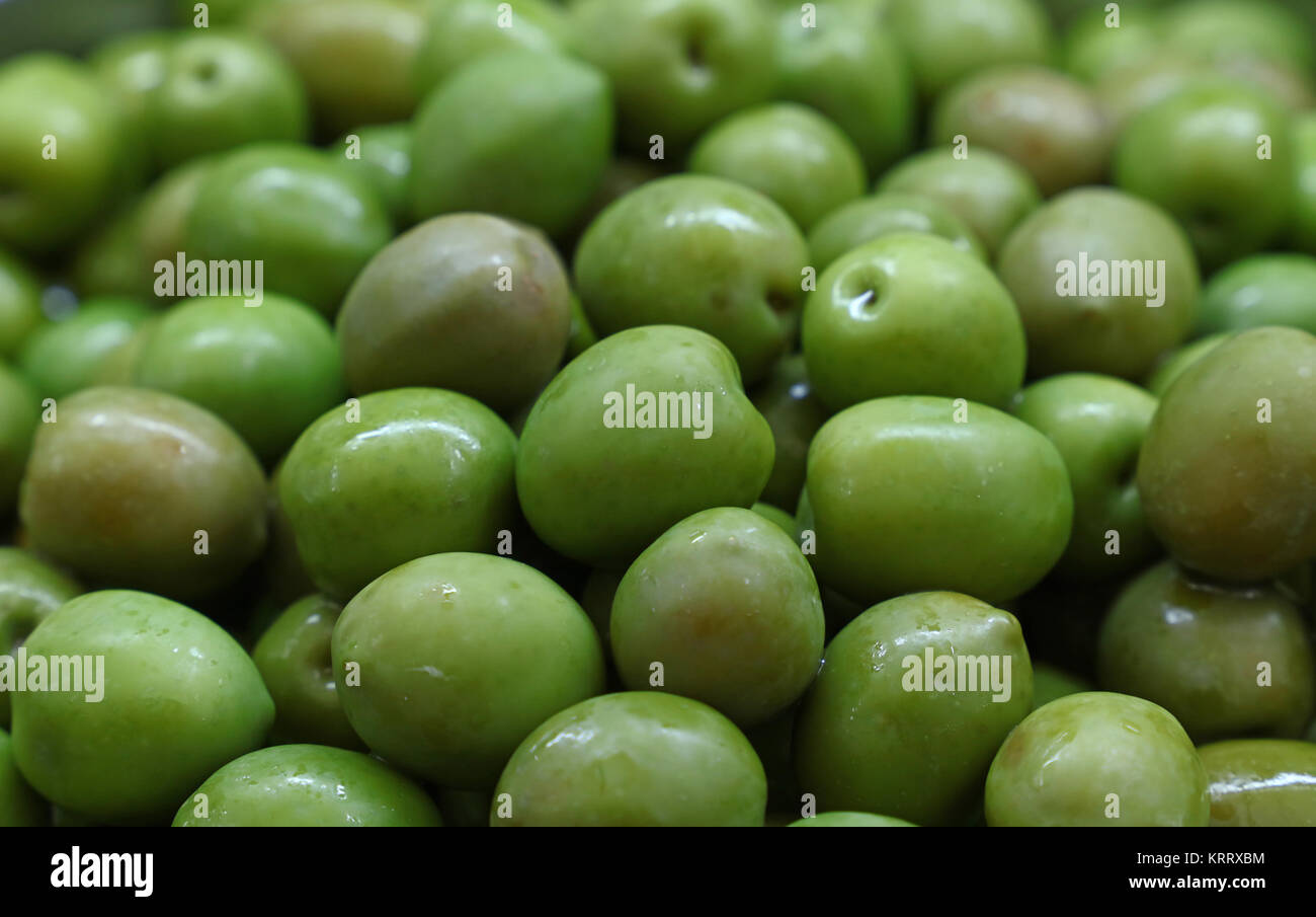 Green whole olives close up background Stock Photo - Alamy