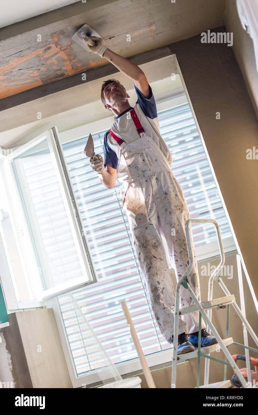Plasterer renovating indoor walls and ceilings. Construction finishing ...