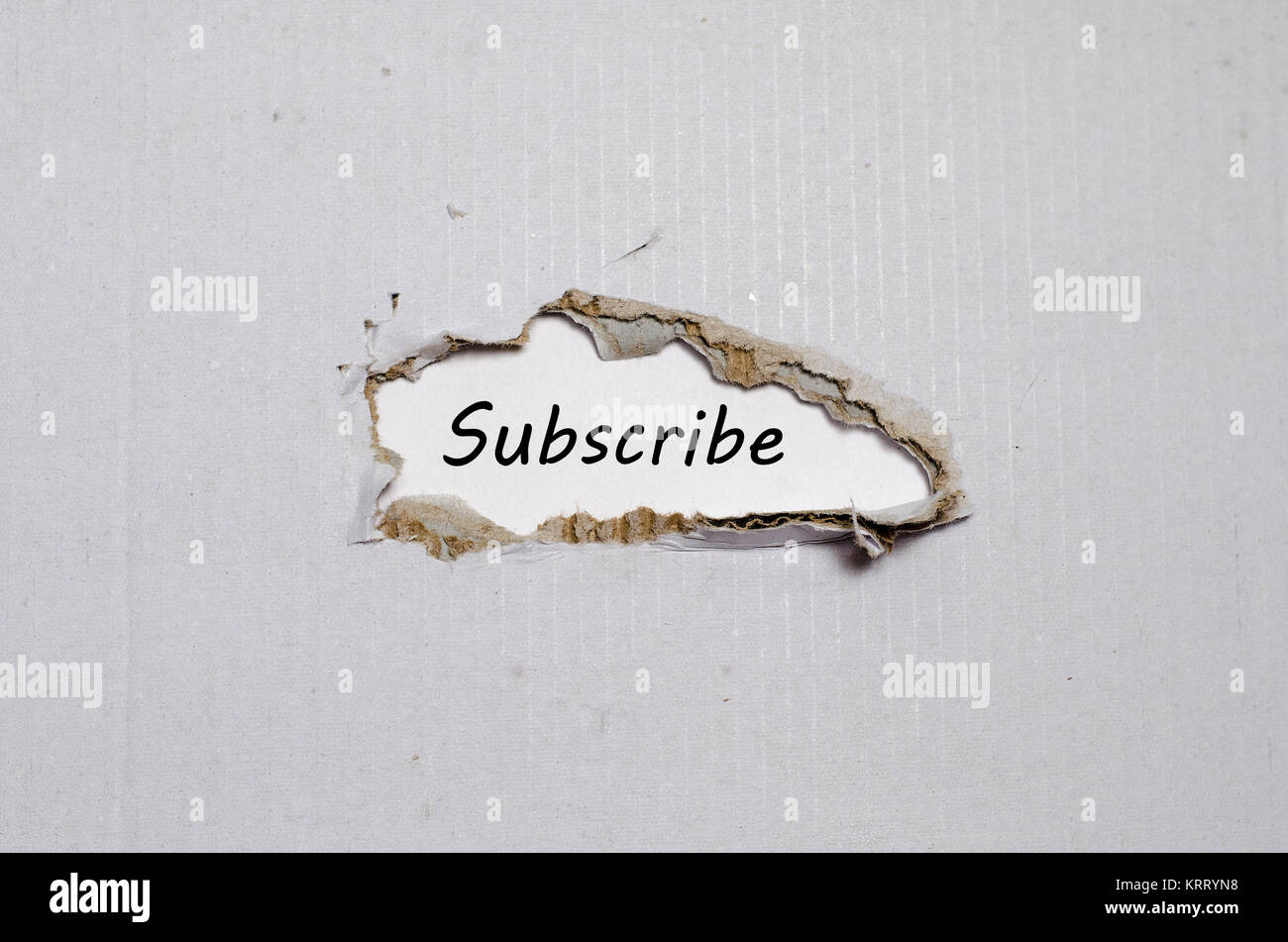 The word subscribe appearing behind torn paper Stock Photo - Alamy