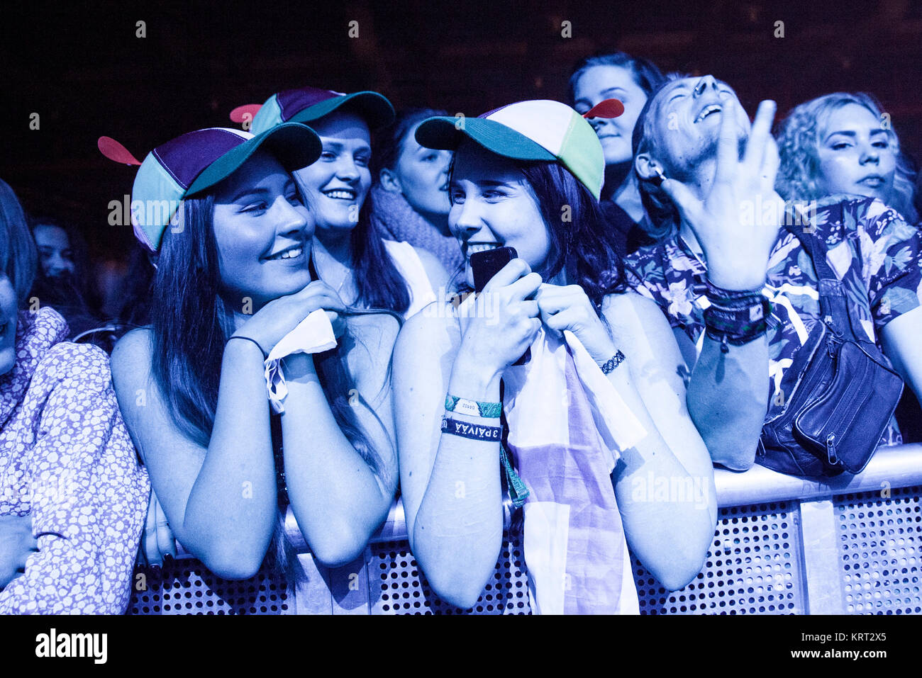 Amused teenagers attend a concert with the British electronica trio ...