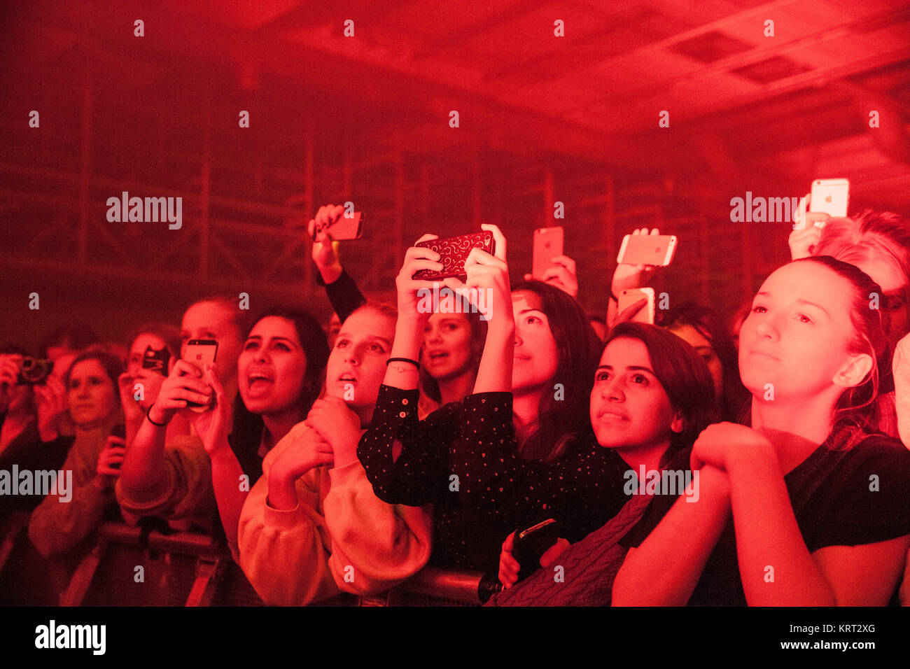 Amused teenagers attend a concert with the British electronica trio ...