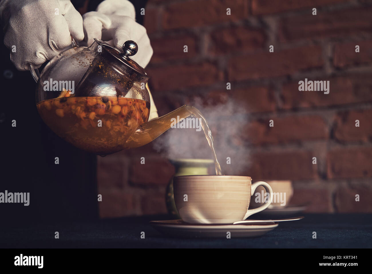 Pouring tea with sea buckthorn Stock Photo - Alamy