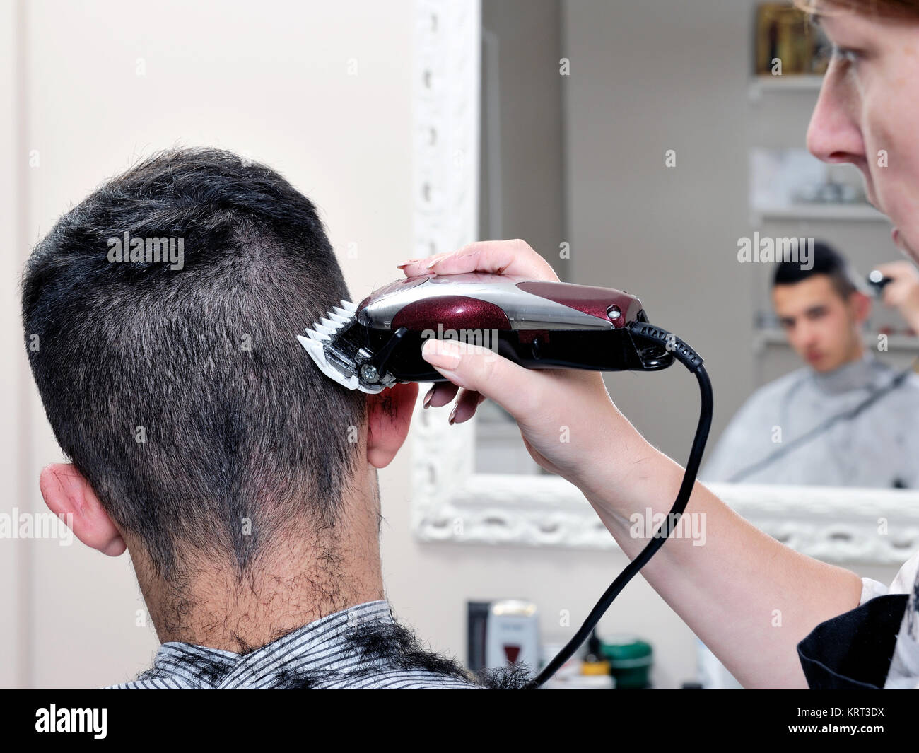 Barber shop that performs the haircut of a young boy with electric ...