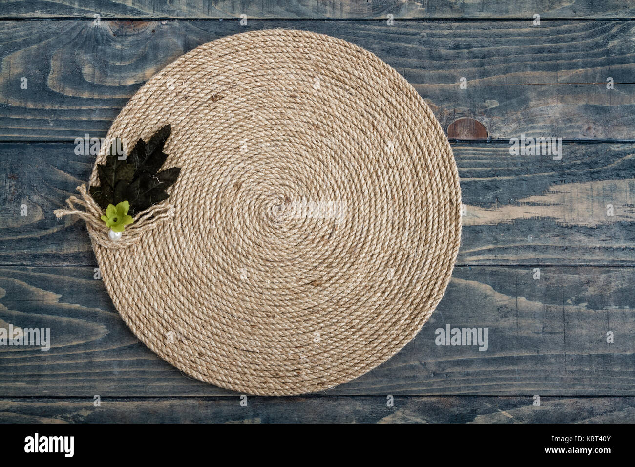 Handmade table mat of Jute Rope twisted in a spiral form on blue wooden ...