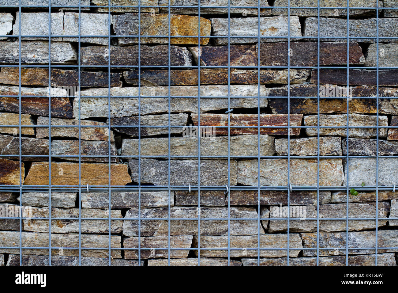 Wall of river stones sustained by metallic net Stock Photo - Alamy