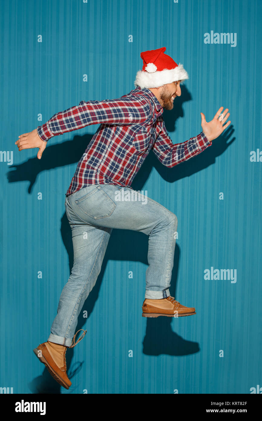 The running christmas man wearing a santa hat Stock Photo - Alamy
