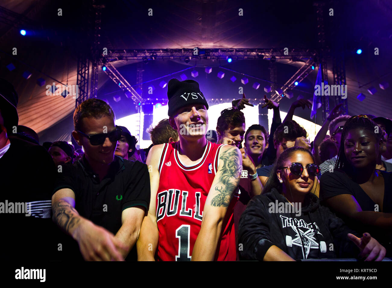 A tattooed rap fan wears a Bulls basketball shirt at front row at a rap ...